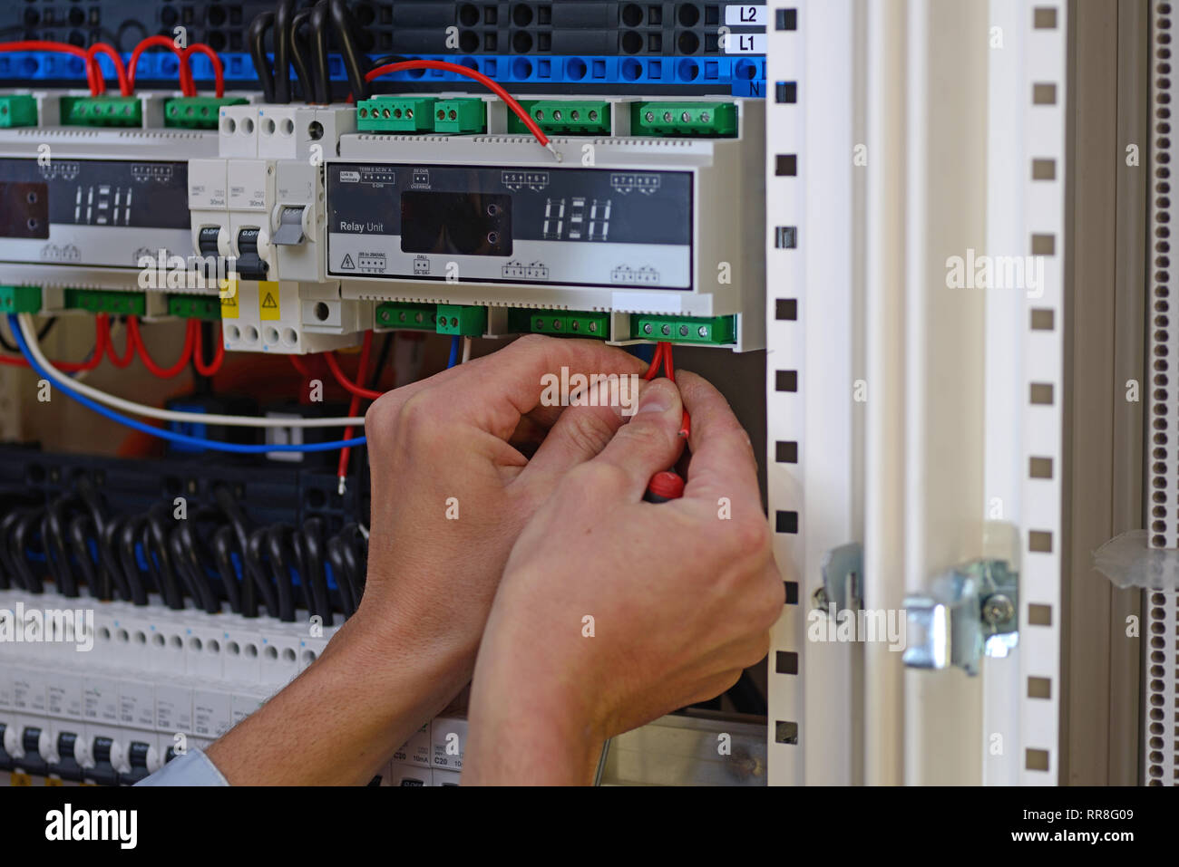 Electrician wiring up a switchboard in a new building Stock Photo - Alamy