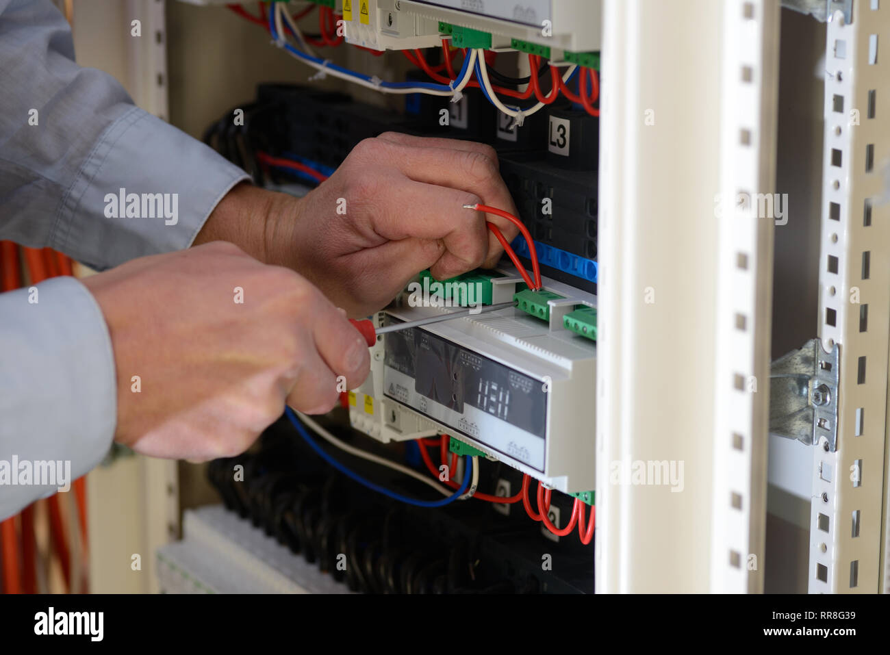 Electrician wiring up a switchboard in a new building Stock Photo - Alamy