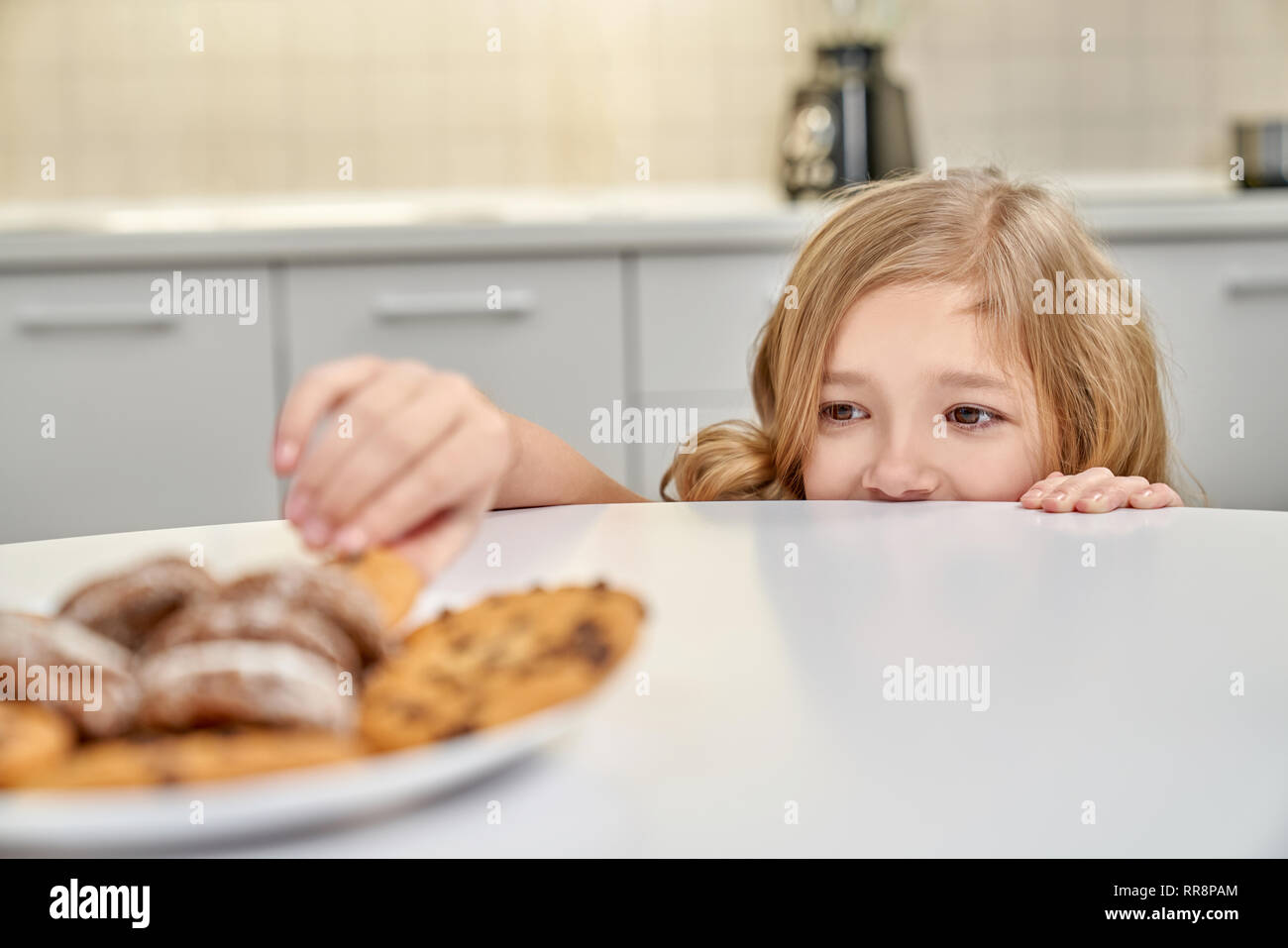 Child secretly taking delicious sweets. American cookies and chocolate ...