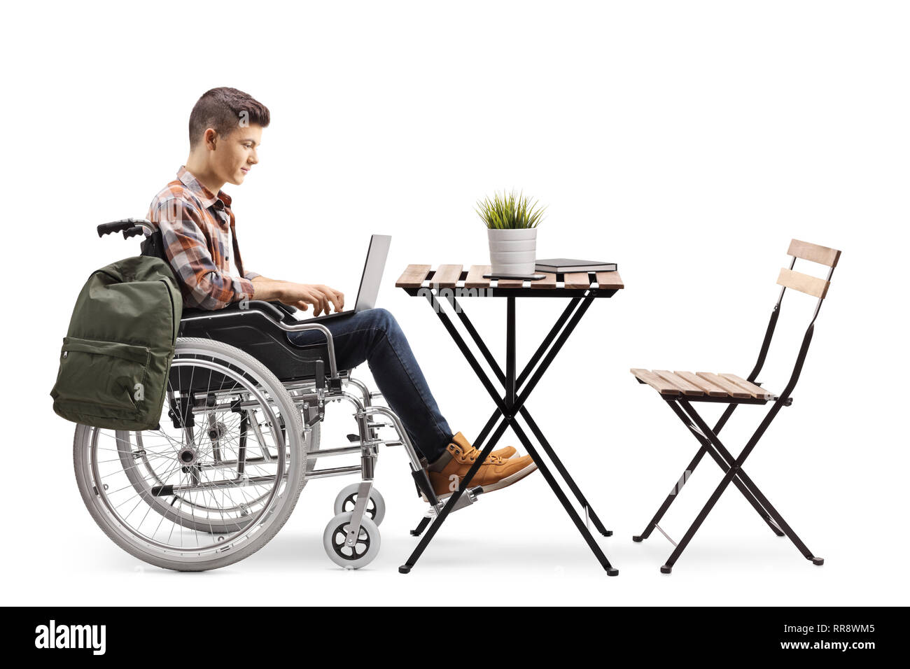 Full length profile shot of a disabled teenage male student working on ...