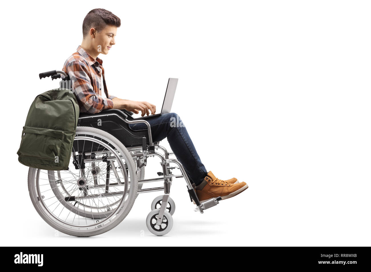 Full length profile shot of a disabled teenage male student working on ...