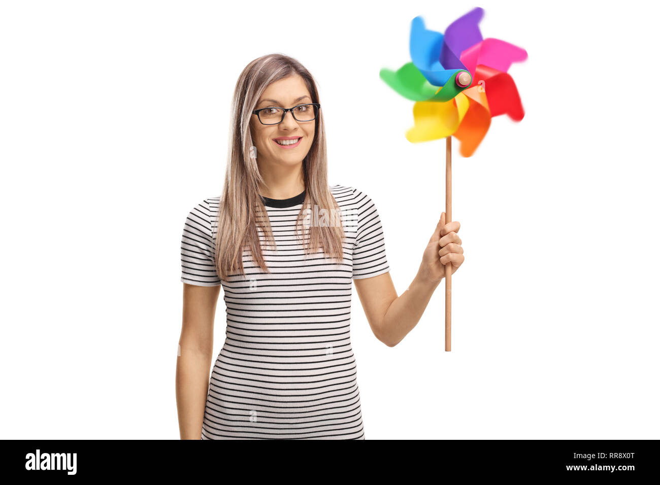 Smiling young woman with a spinning pinwheel in her hand isolated on ...