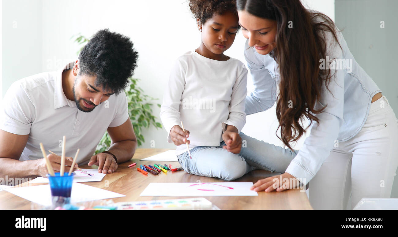 Mother and father drawing together with their child Stock Photo - Alamy