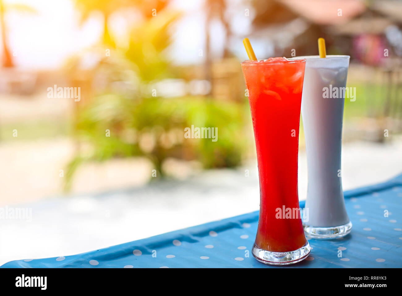 Tequila sunrise and pina colada cocktails on the table under the palms ...