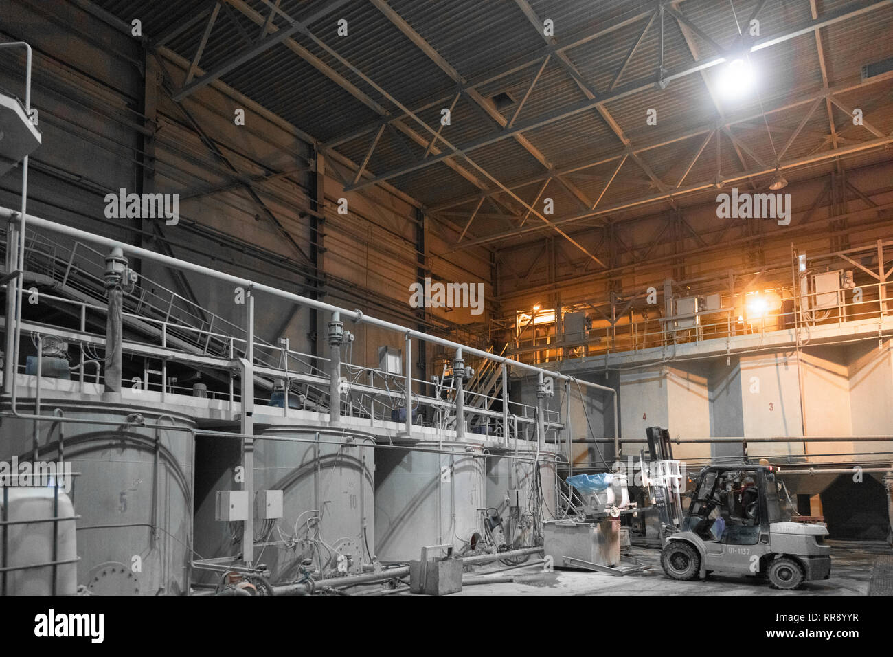 loader performs work in a dusty room at the plant Stock Photo - Alamy