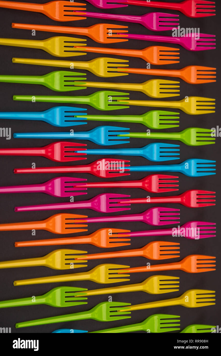 Many color plastic forks on a bright background Stock Photo - Alamy