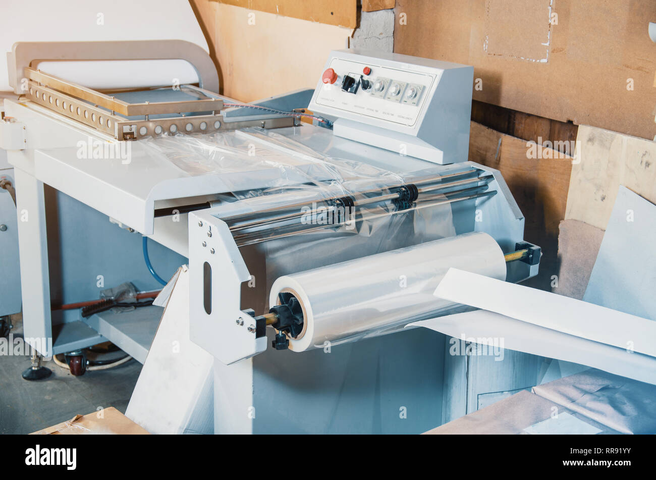 Machine for packing products with the plastic wrap Stock Photo - Alamy
