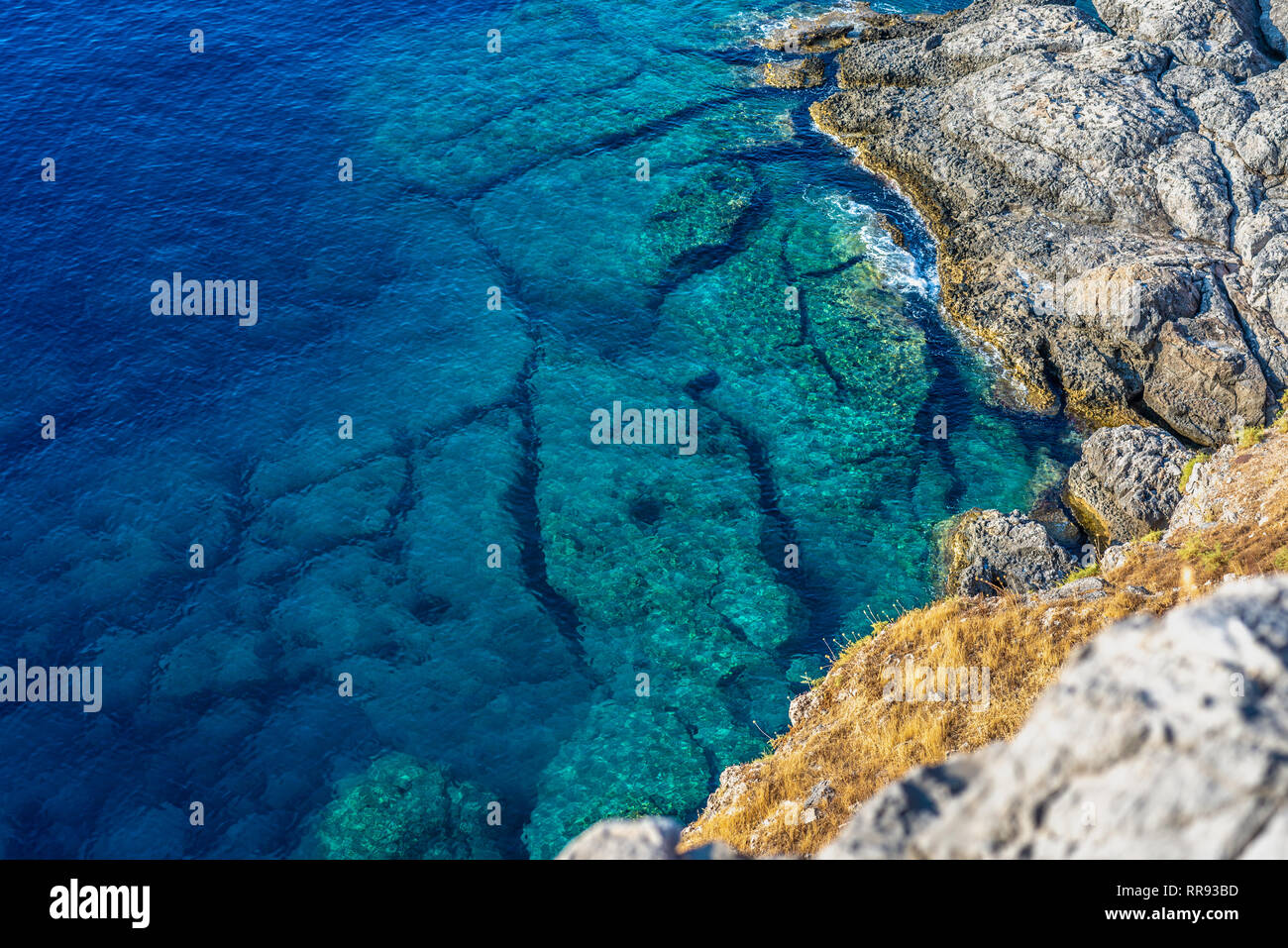 Top view of beautiful blue sea with rock bottom and cliff rising from ...