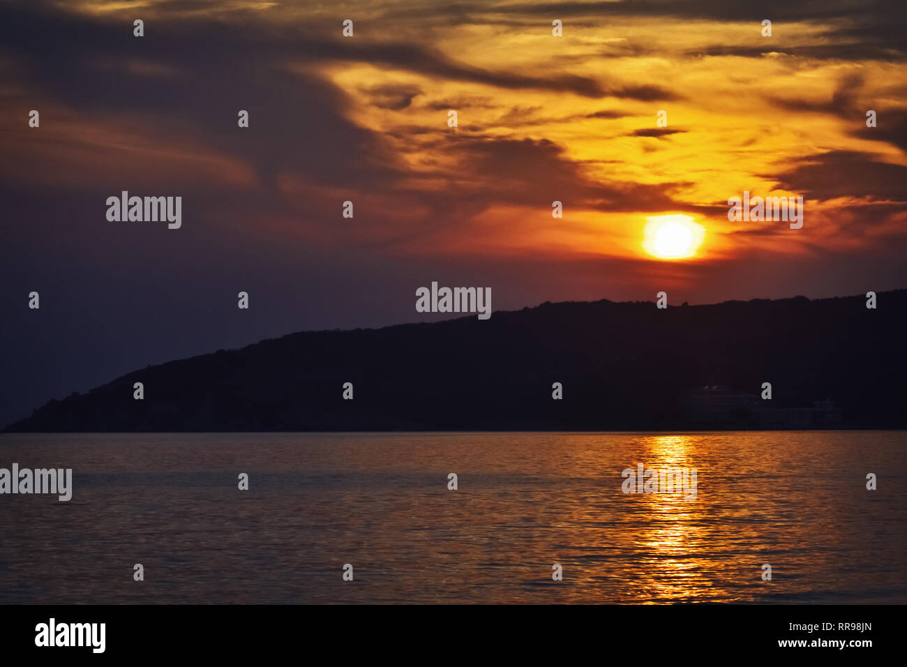 Moody golden sunset over the sea after a hot summer day Stock Photo - Alamy