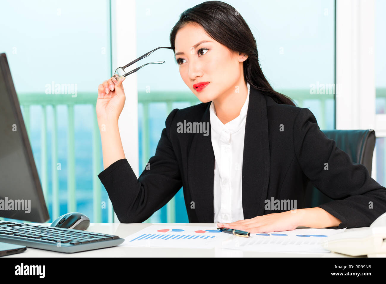 Thoughtful businesswoman looking at computer Stock Photo - Alamy