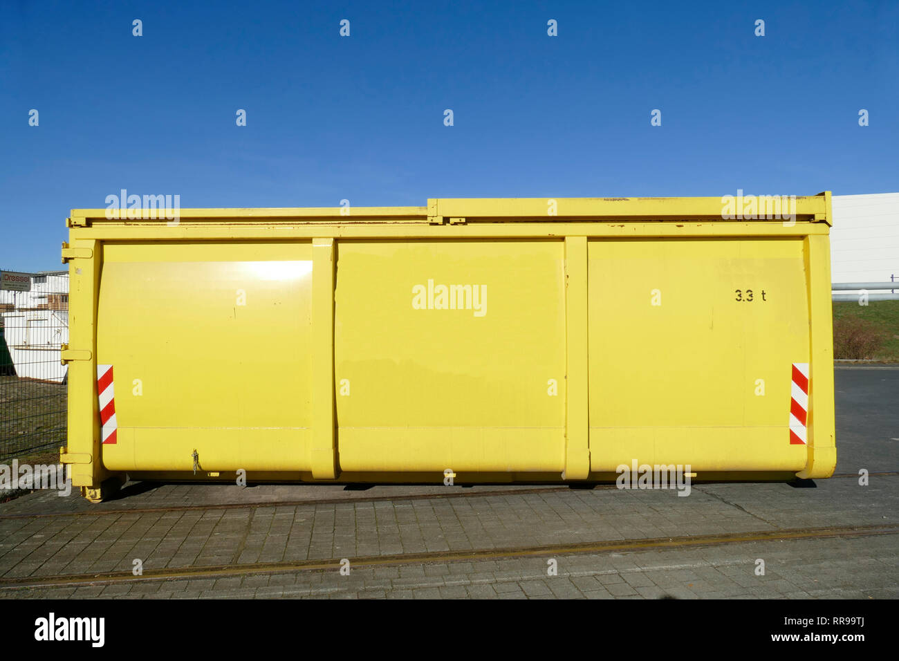 Yellow Container for rubble, blue sky Stock Photo - Alamy