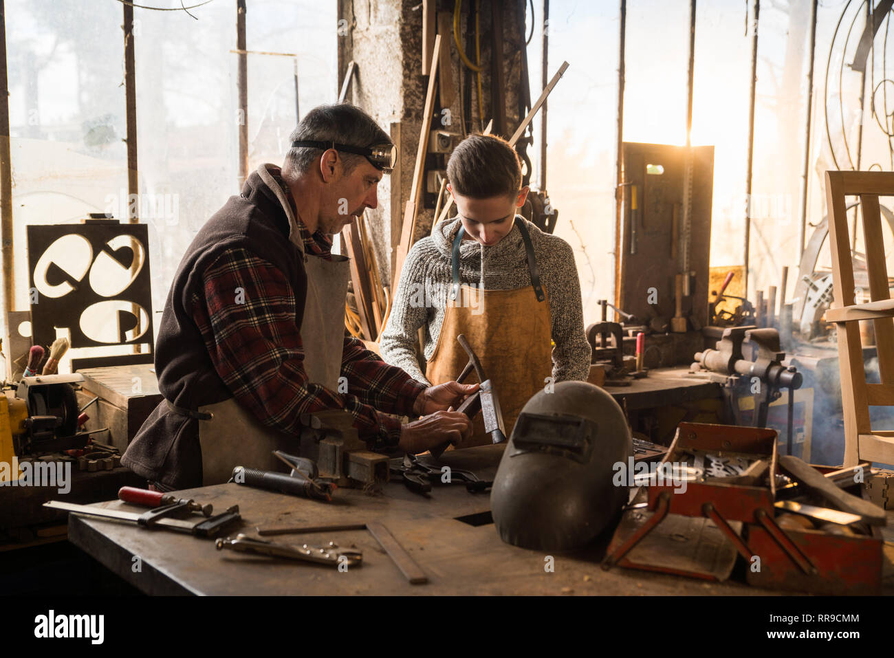 A Craftsman In His Workshop Teaches His Work To His Apprentice Stock