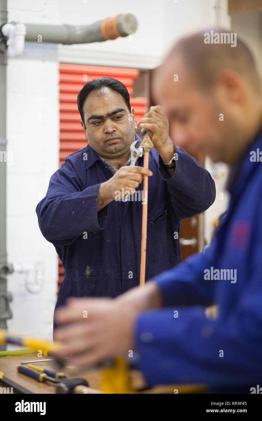 adults in a further education college studying plumbing Stock Photo - Alamy