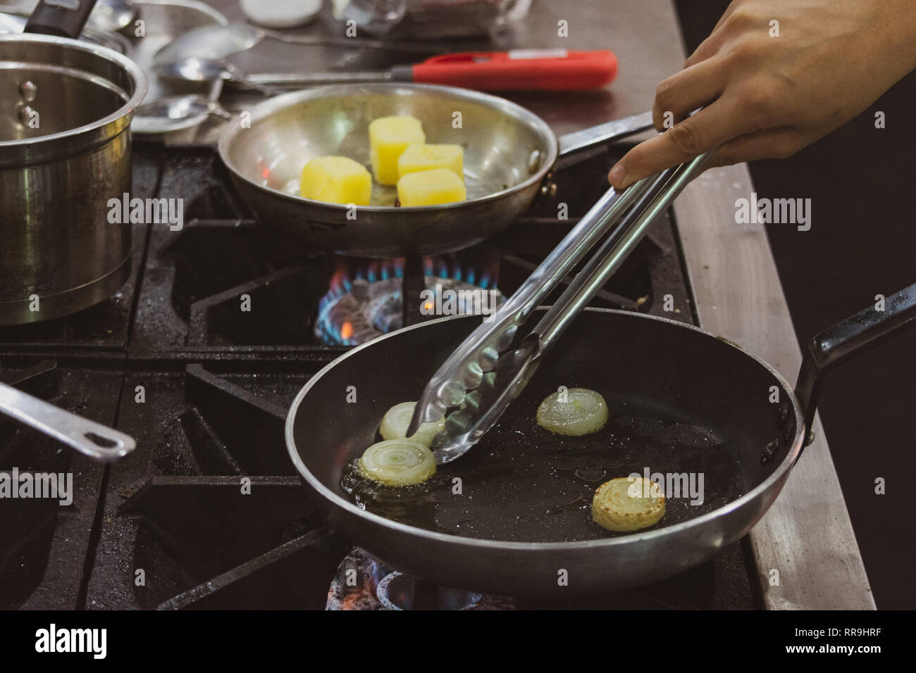 Chef cooking food in the kitchen, stir fried vegetables in the pan ...