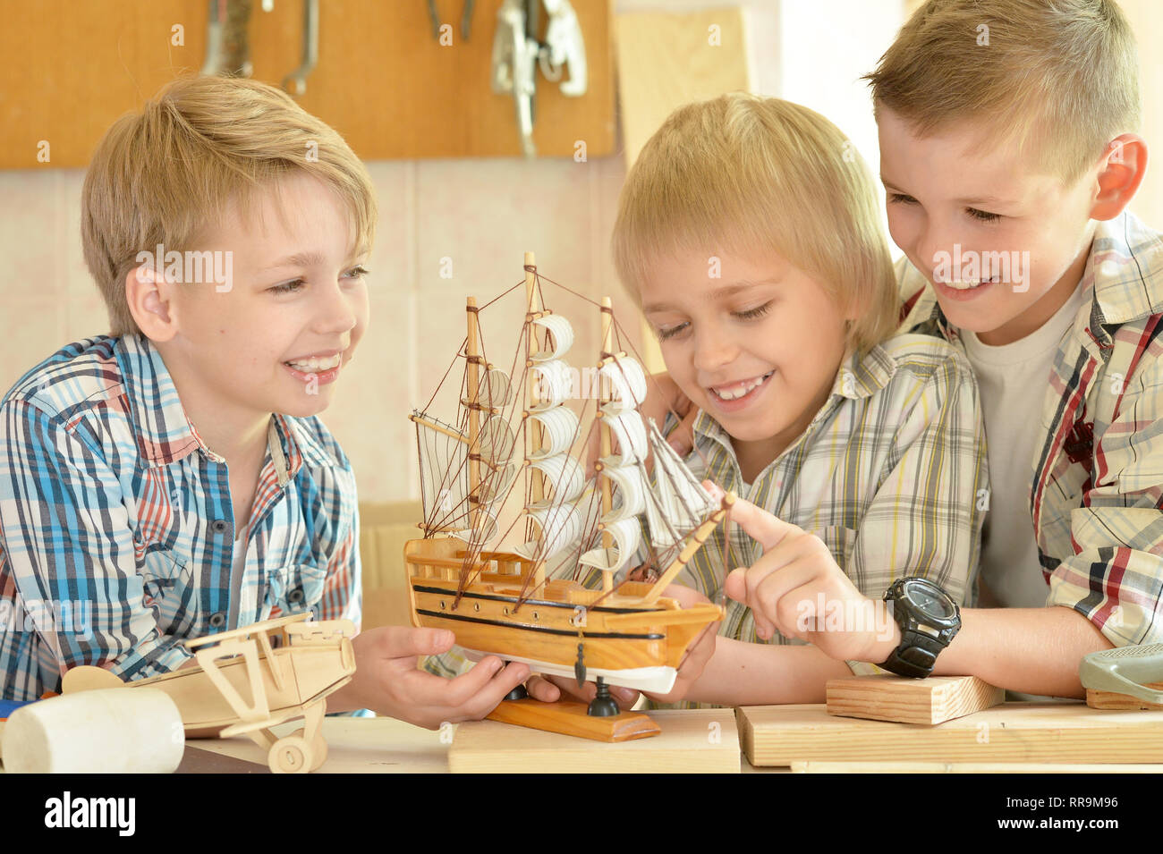 Portrait of cute little boys working with wood in workshop Stock Photo ...