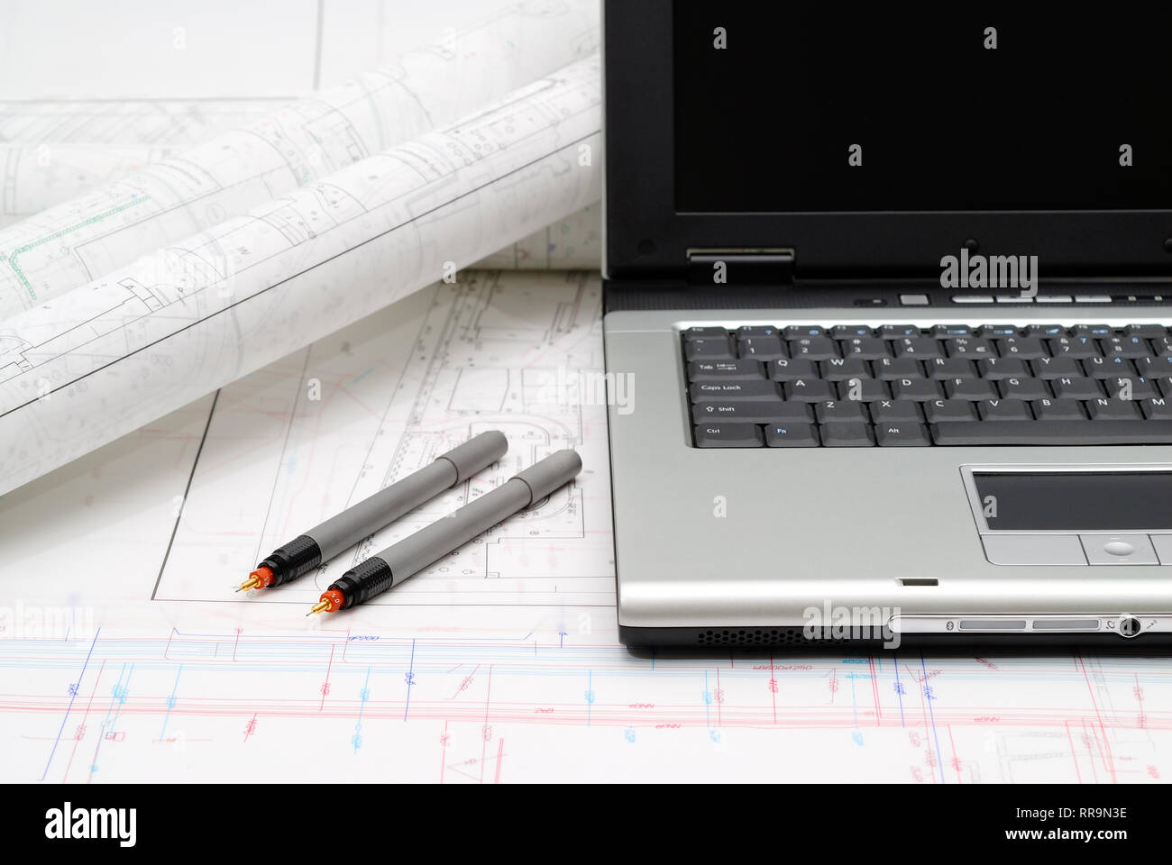 Computer with architectural plans lying on table Stock Photo - Alamy