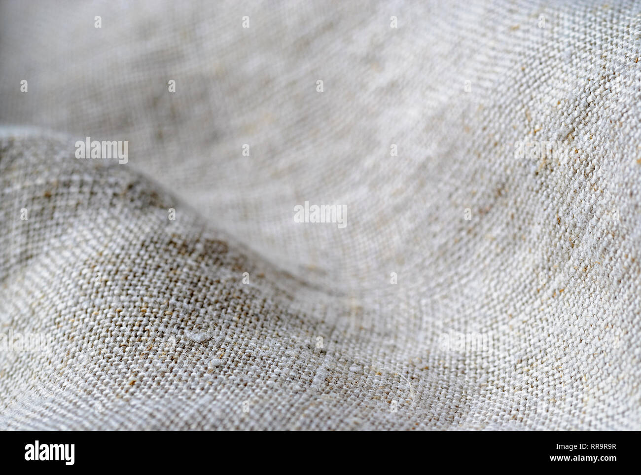 Texture if natural linen fabric draped in waves in a full frame ...