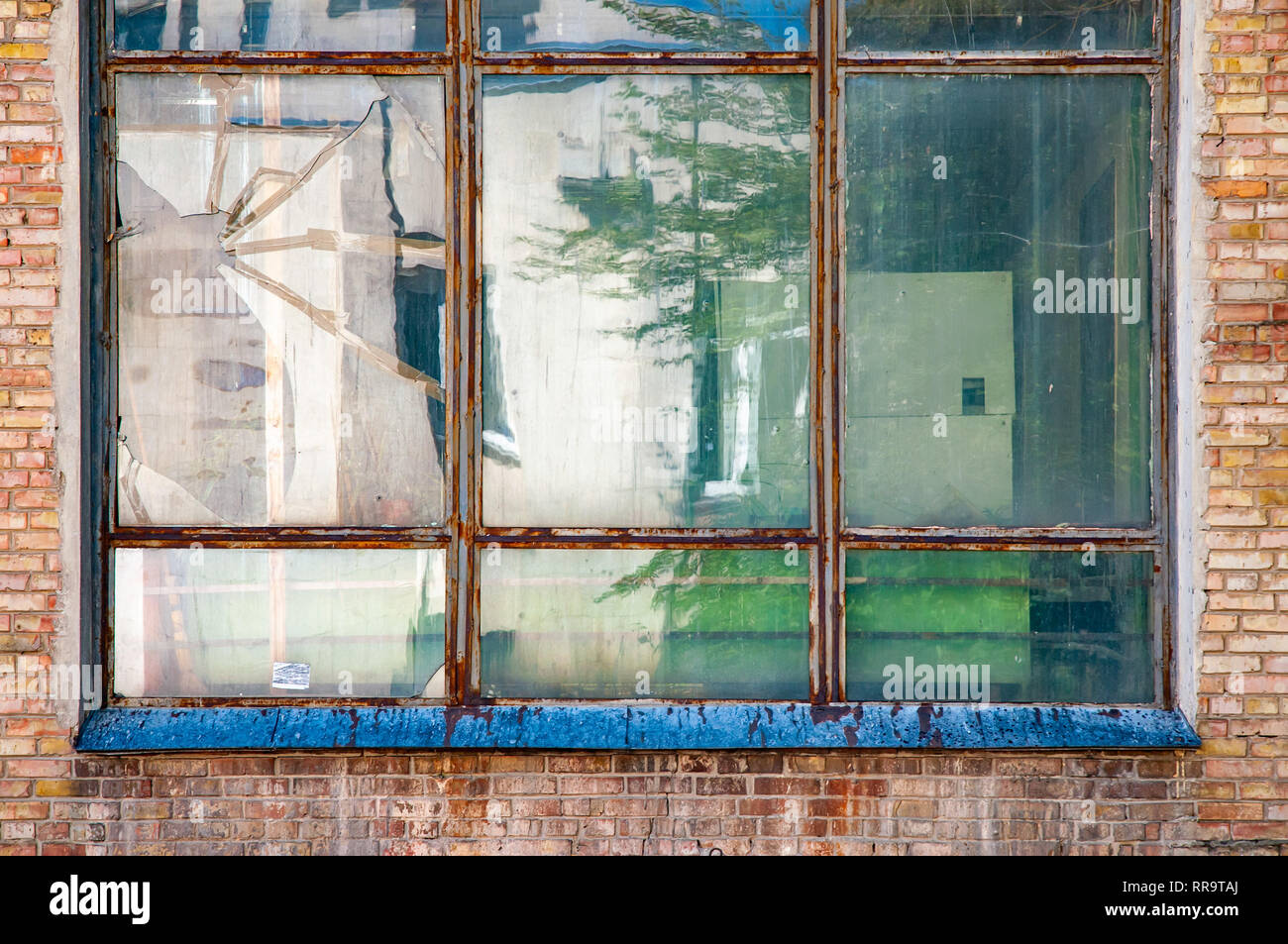 Old metallic window surrounded by red bricks in a soviet building of ...