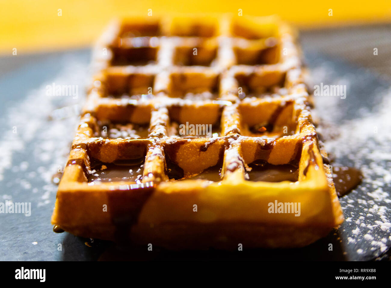Belgian waffle with chocolate syrup and powdered sugar Stock Photo - Alamy