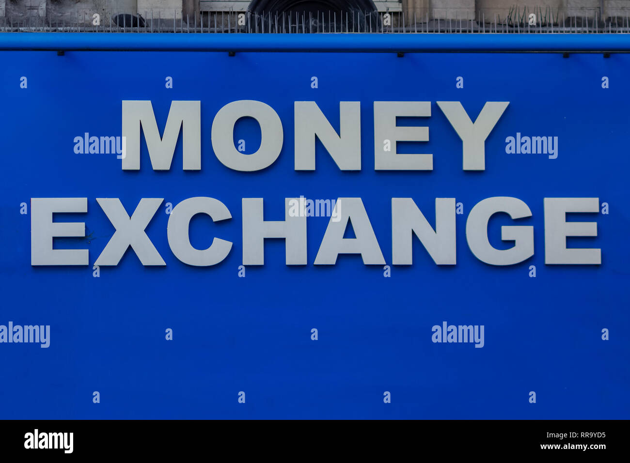 Close up view of blue light Money Exchange sign with spikes on top ...