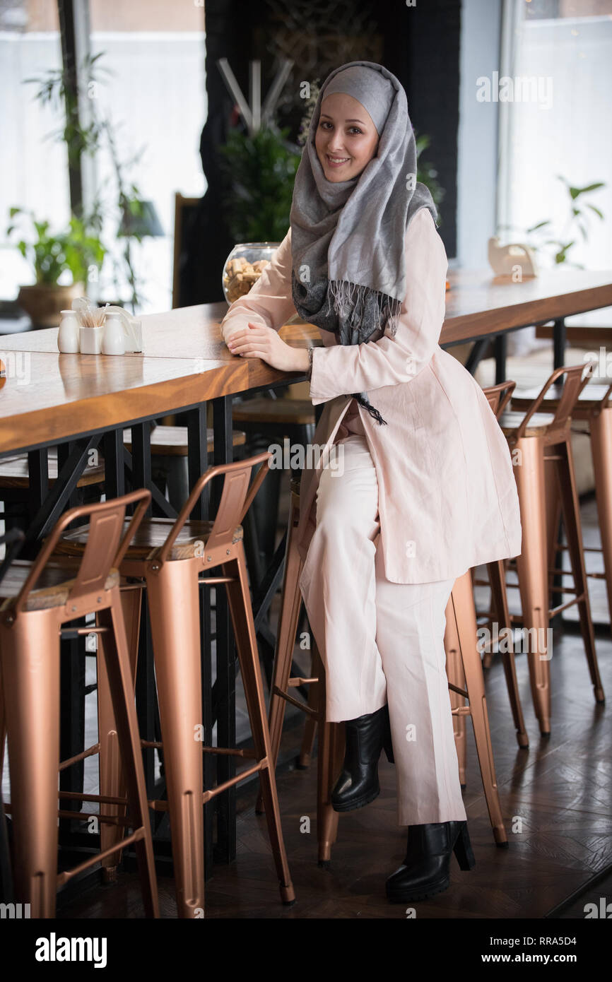 A young muslim woman sitting on a bar chair Stock Photo - Alamy