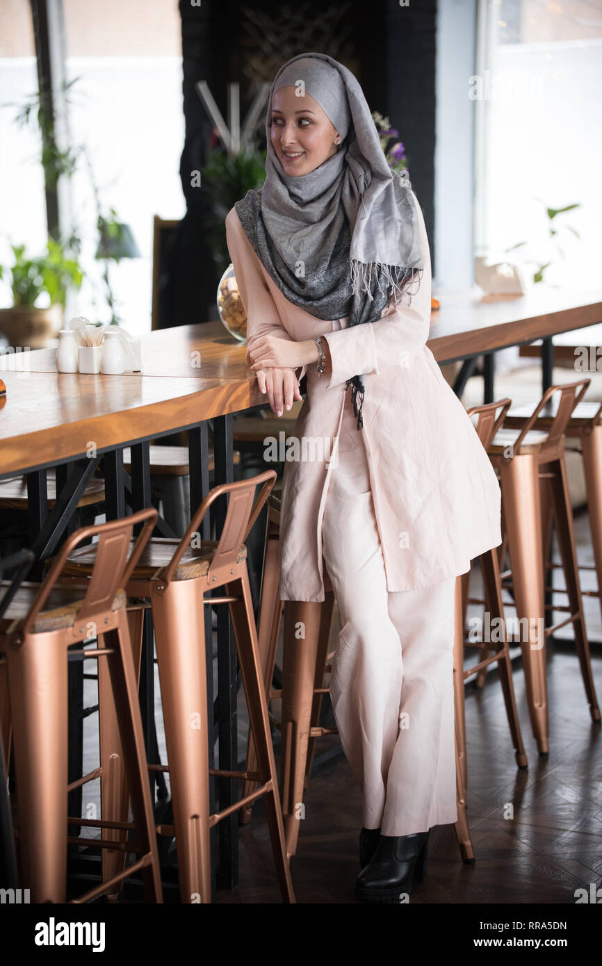 A young muslim woman sitting on a bar chair in a restaurant Stock Photo ...
