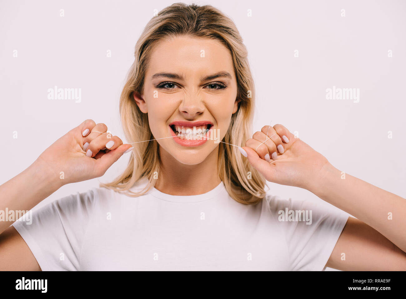 beautiful woman biting dental floss and looking at camera isolated on ...