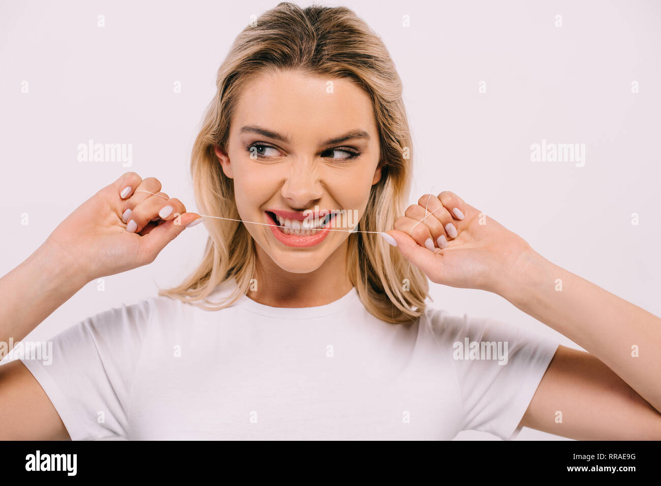 beautiful woman biting dental floss and looking at camera isolated on ...