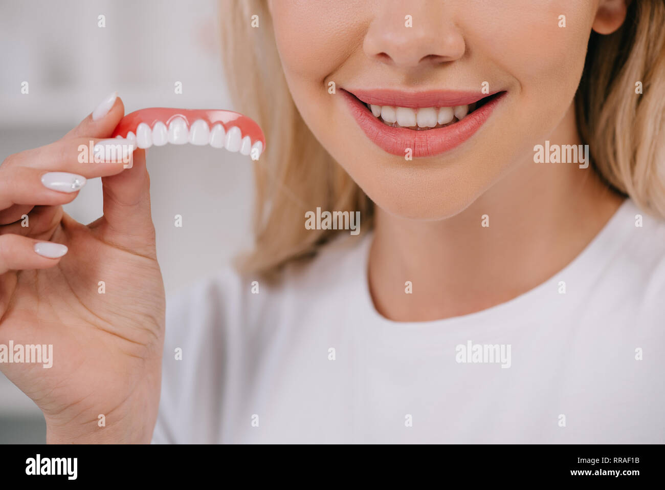 cropped view of smiling woman holding teeth cover Stock Photo - Alamy