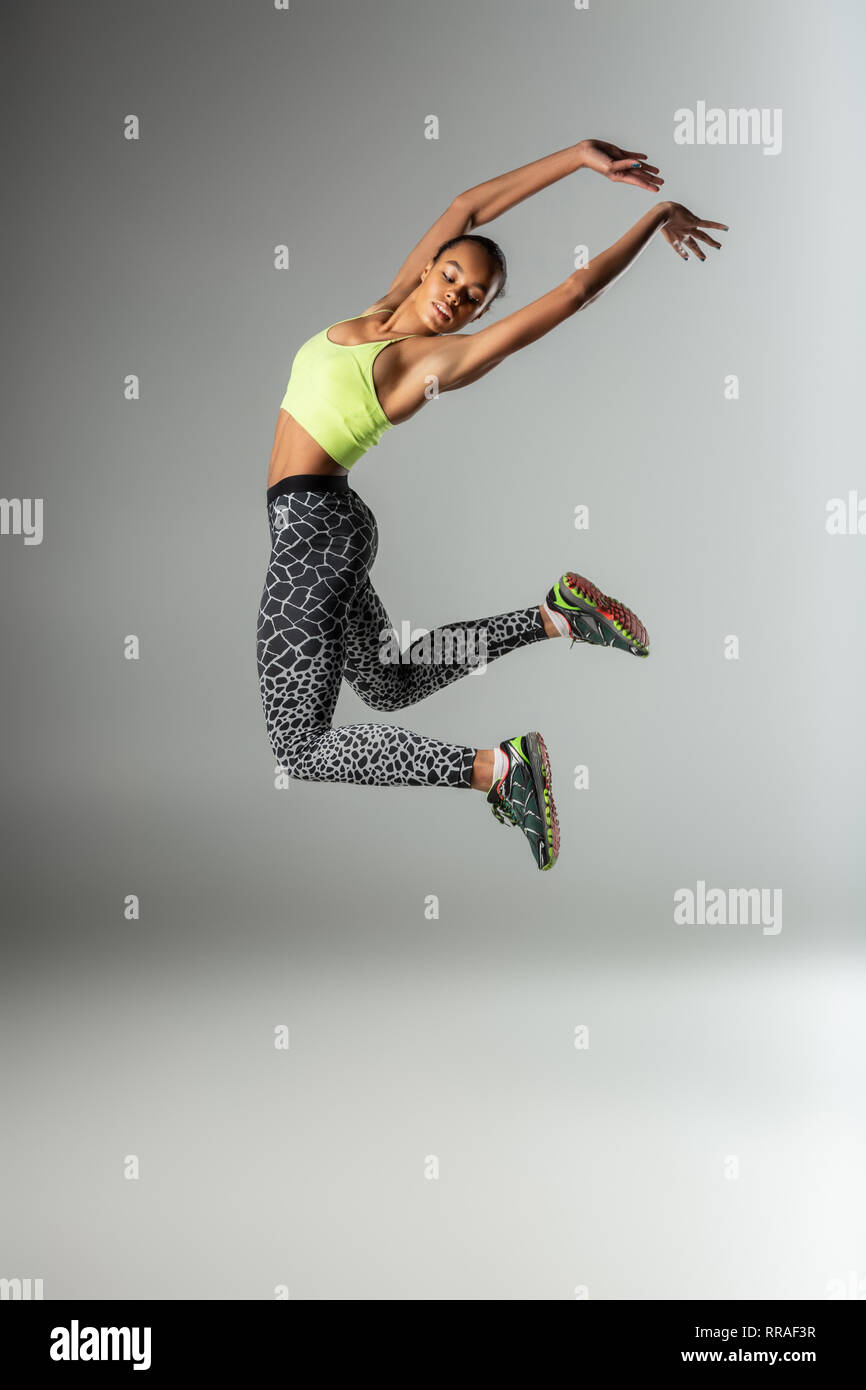 Serious dark-skinned female person demonstrating her jump Stock Photo ...