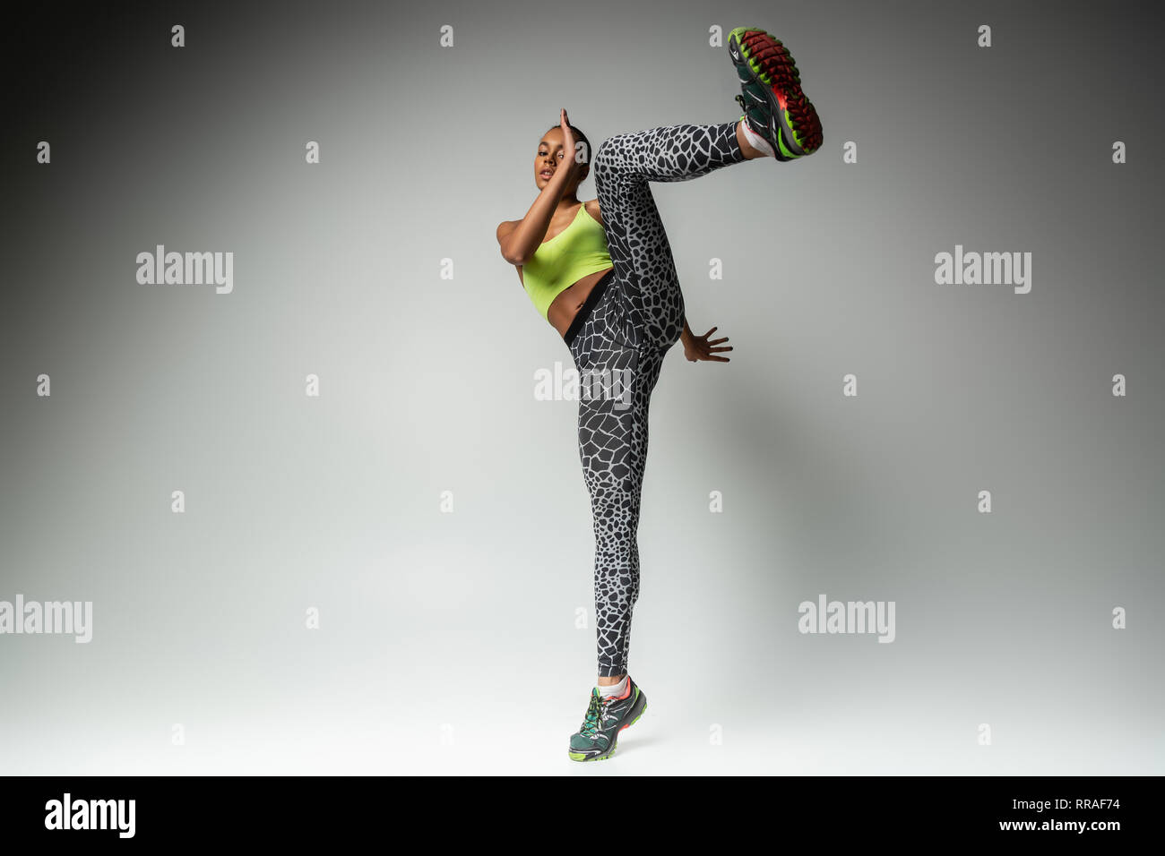 Serious international girl standing on right leg Stock Photo - Alamy