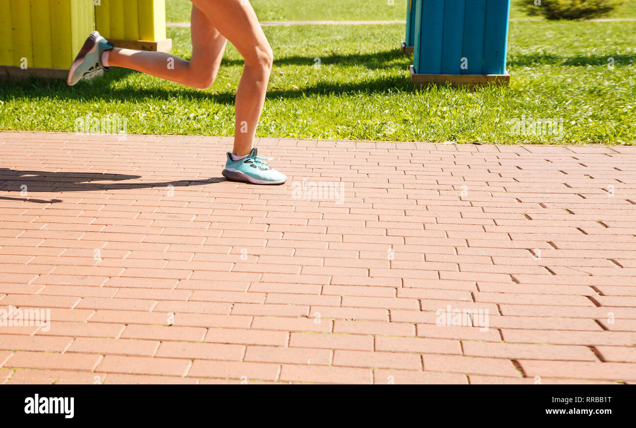 legs of girl running in a sports competition on sunny summer morning ...