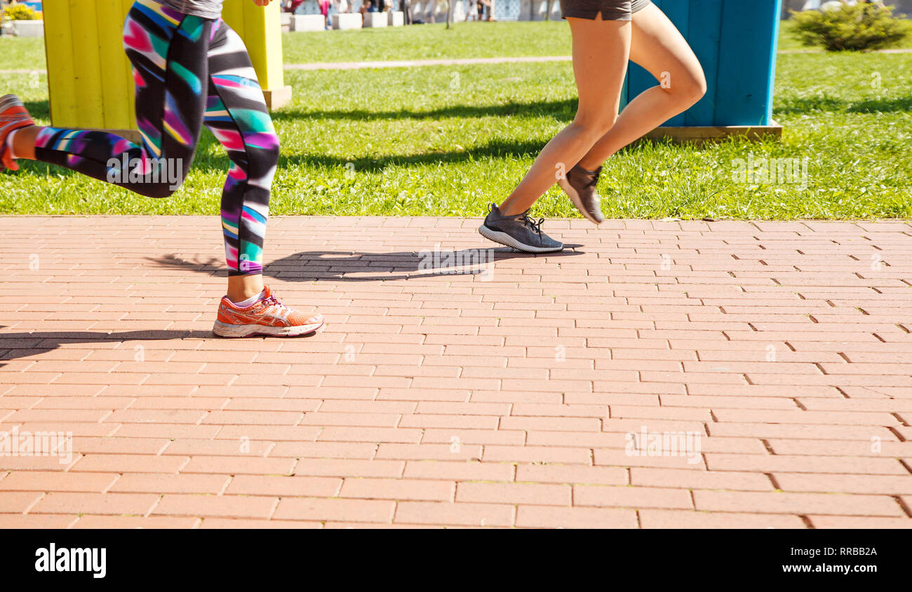 legs of girls running in a sports competition on sunny summer morning ...