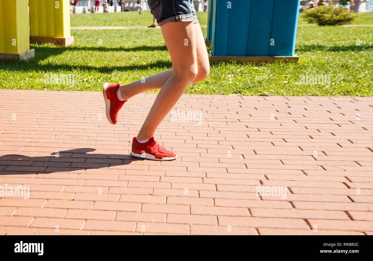 legs of girl running in a sports competition on sunny summer morning ...