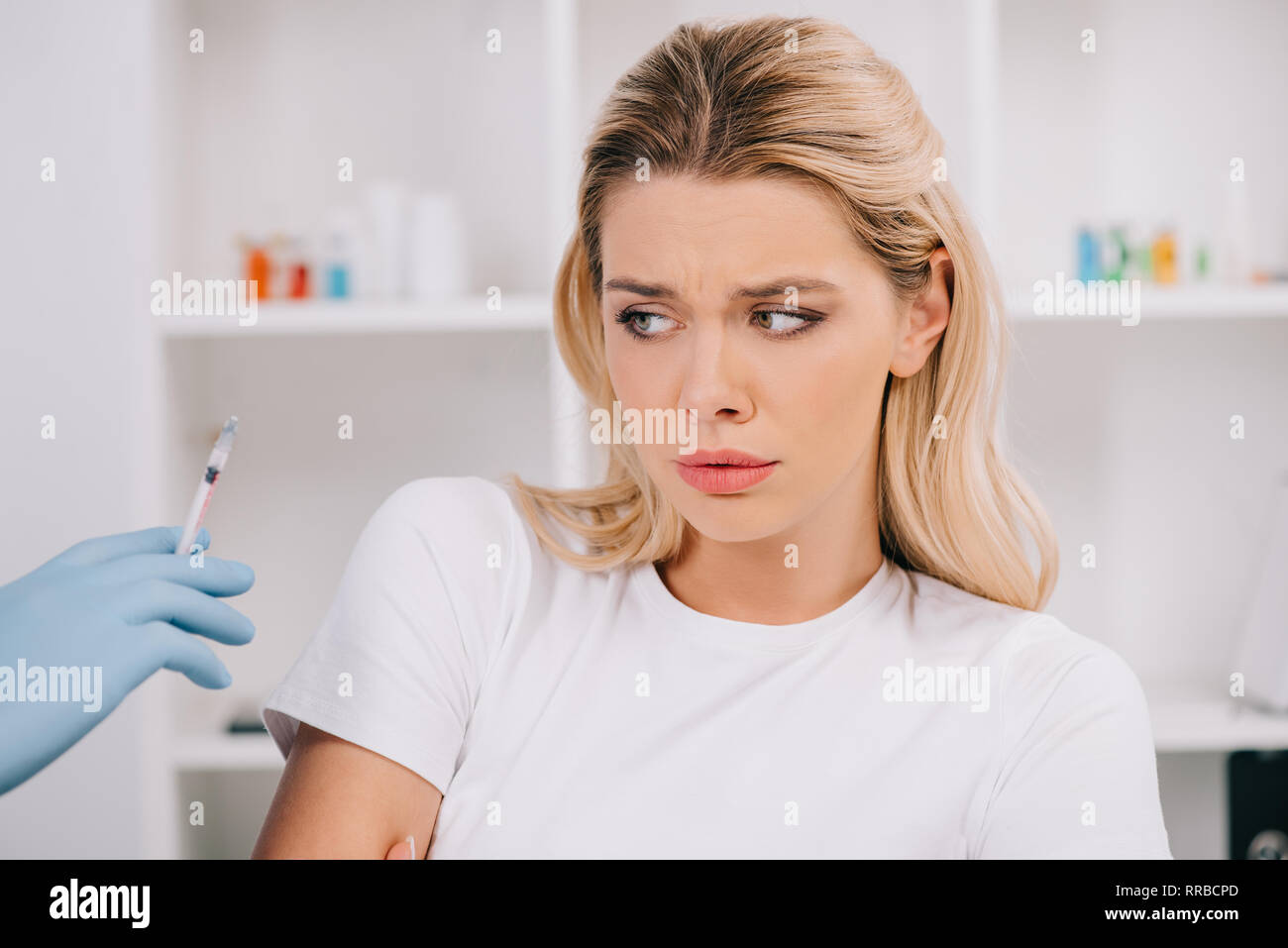 scared woman looking at dentist holding syringe with local anesthesia ...