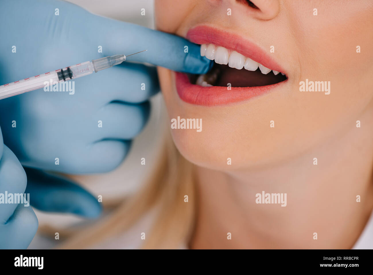 cropped view of dentist giving local anesthesia injection to woman ...