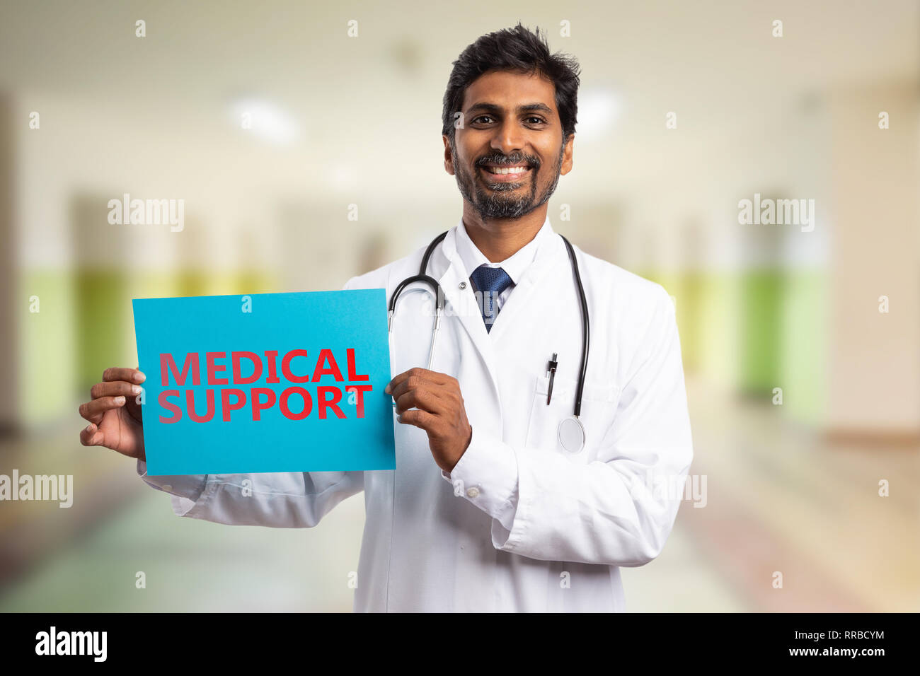 Indian medic man presenting medical support text on blue paper by ...