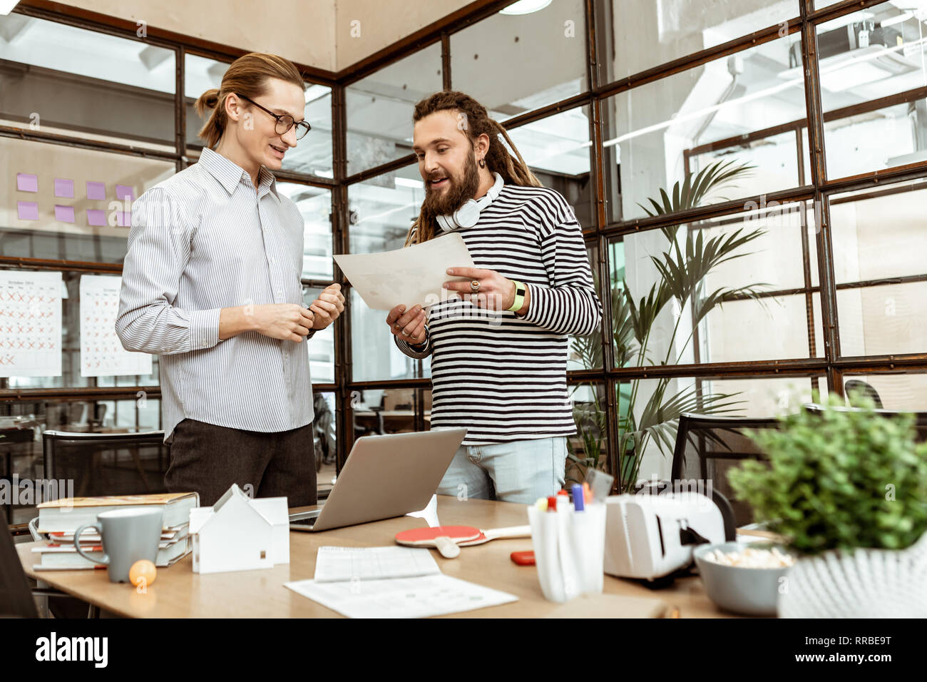 Nice positive young colleagues discussing their work Stock Photo - Alamy