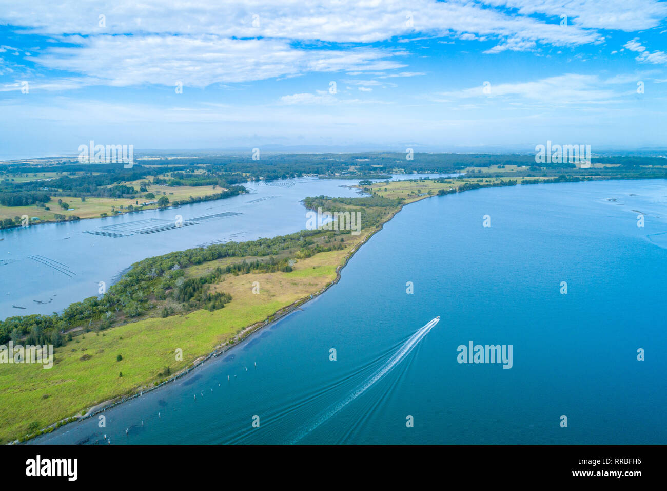 Boat sailing on the Manning River leaving water trail - aerial view ...