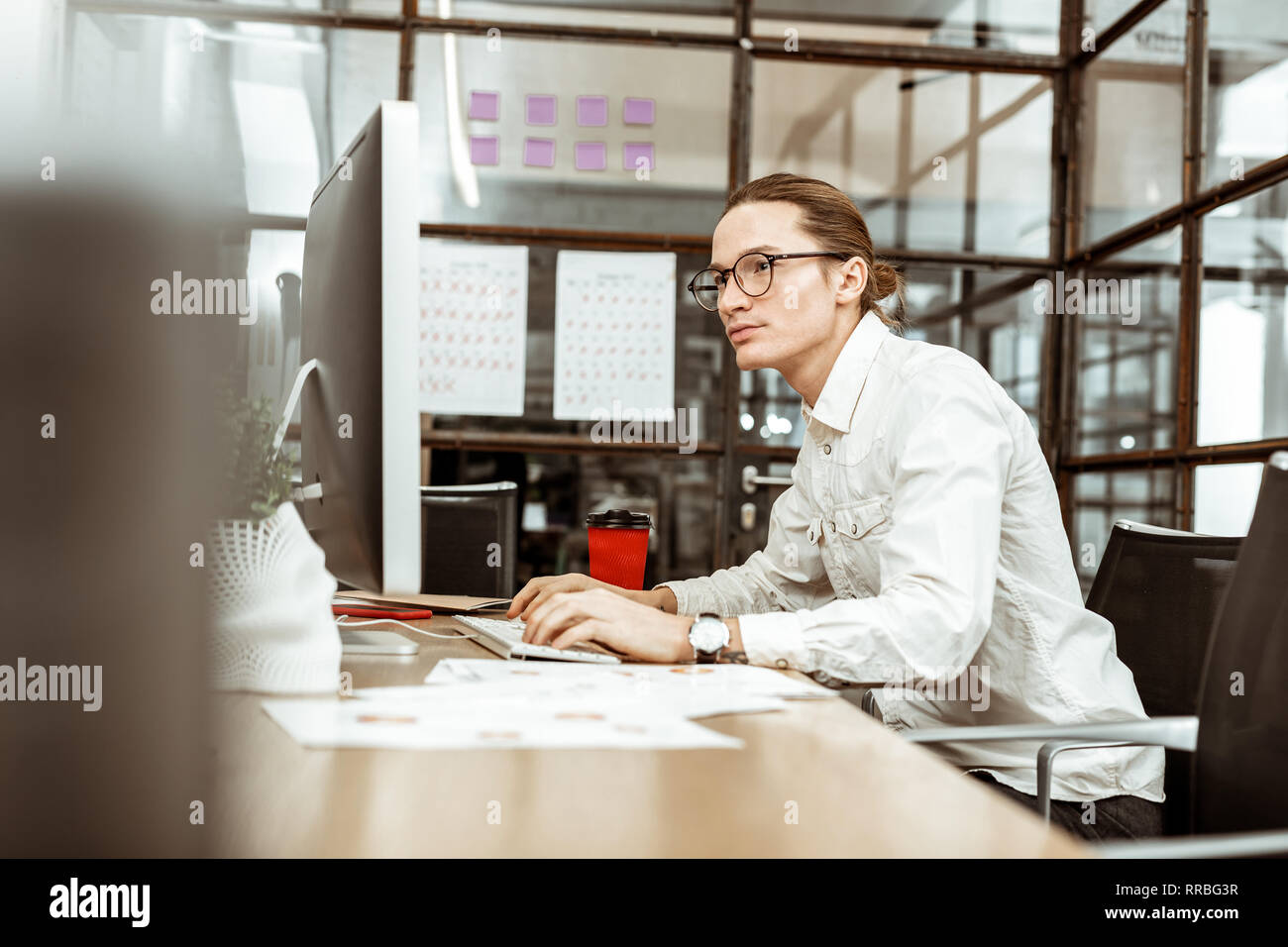 Serious smart man sitting at the computer Stock Photo - Alamy