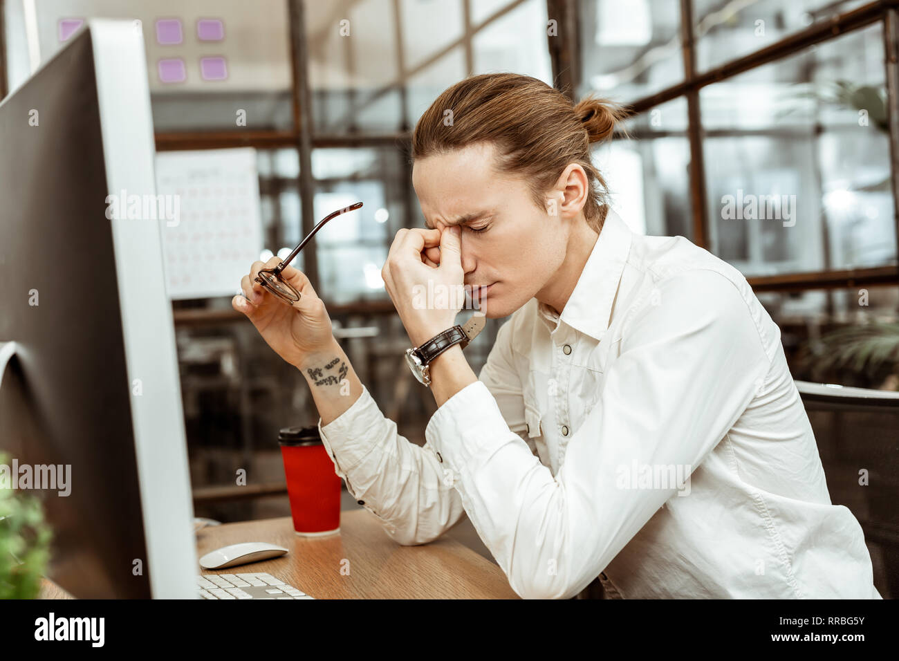 Pleasant young man taking off his glasses Stock Photo - Alamy