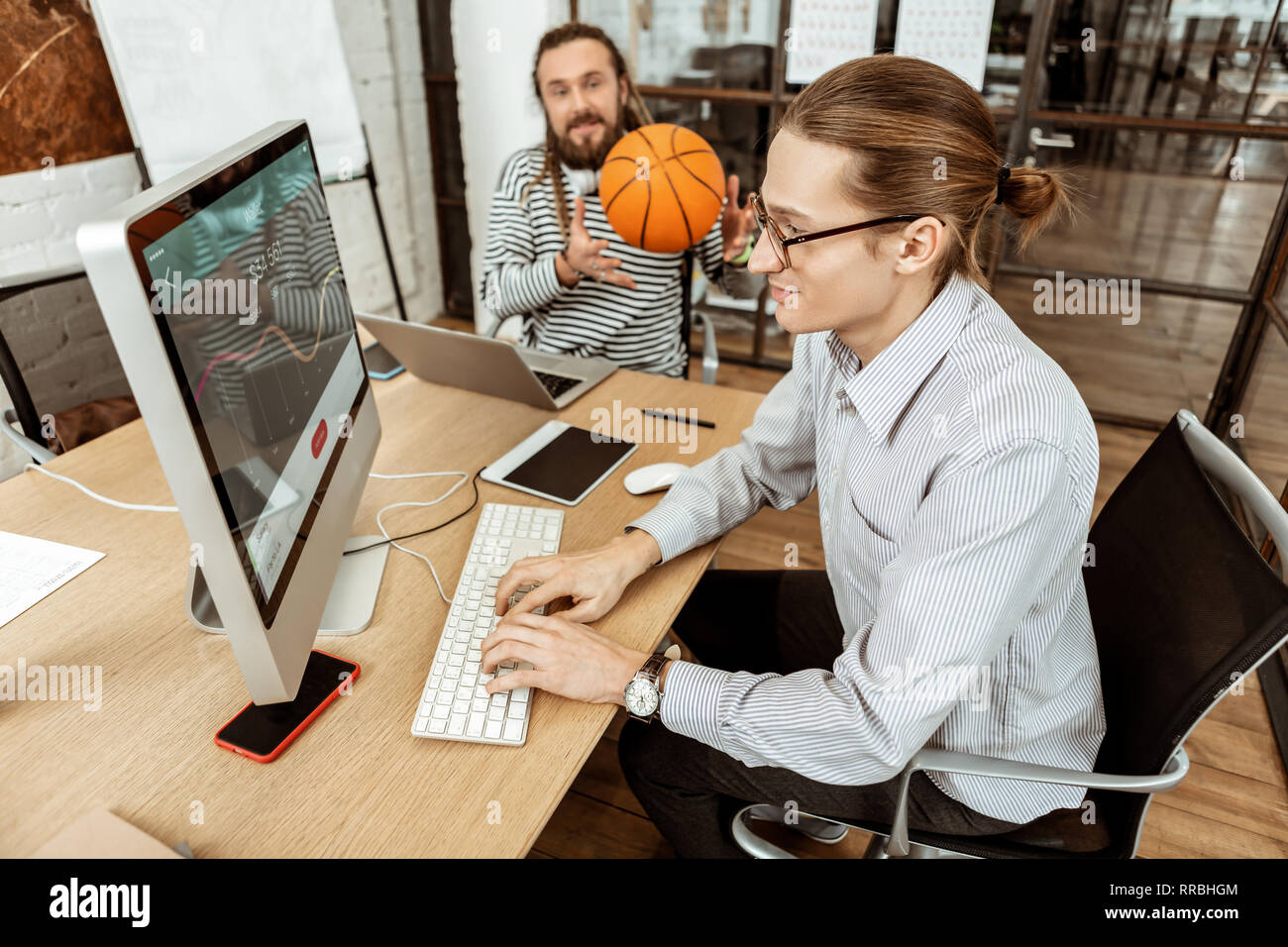 Positive young man trying to focus on his work Stock Photo - Alamy