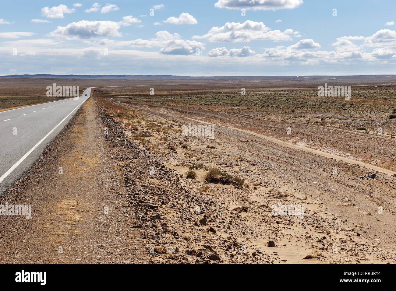 asphalt road Sainshand Zamiin-Uud in Mongolia, desert landscape Gobi ...