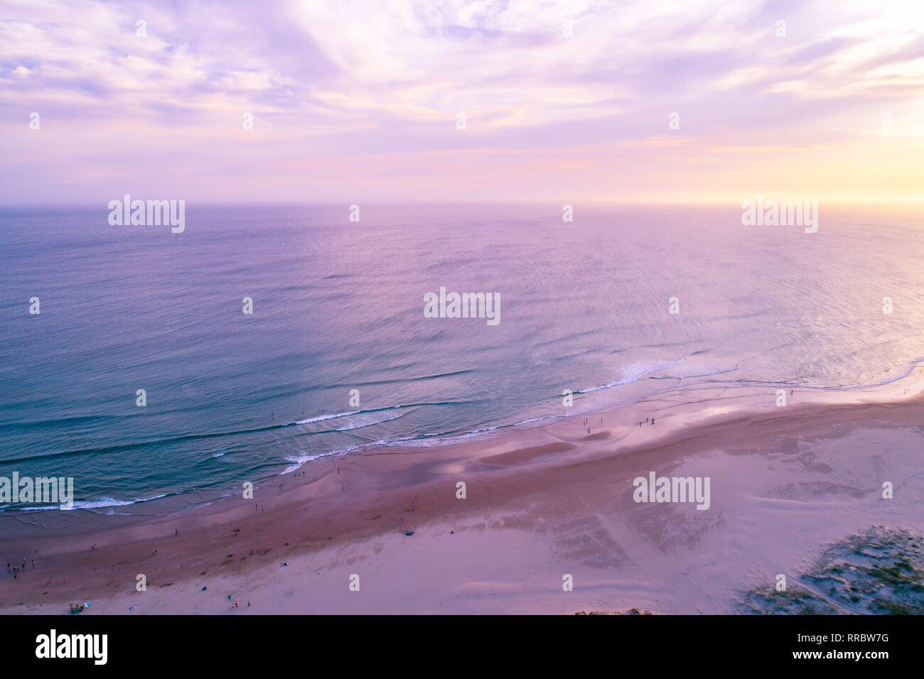 Aerial view of people enjoying the ocean beach at sunset in Australia ...
