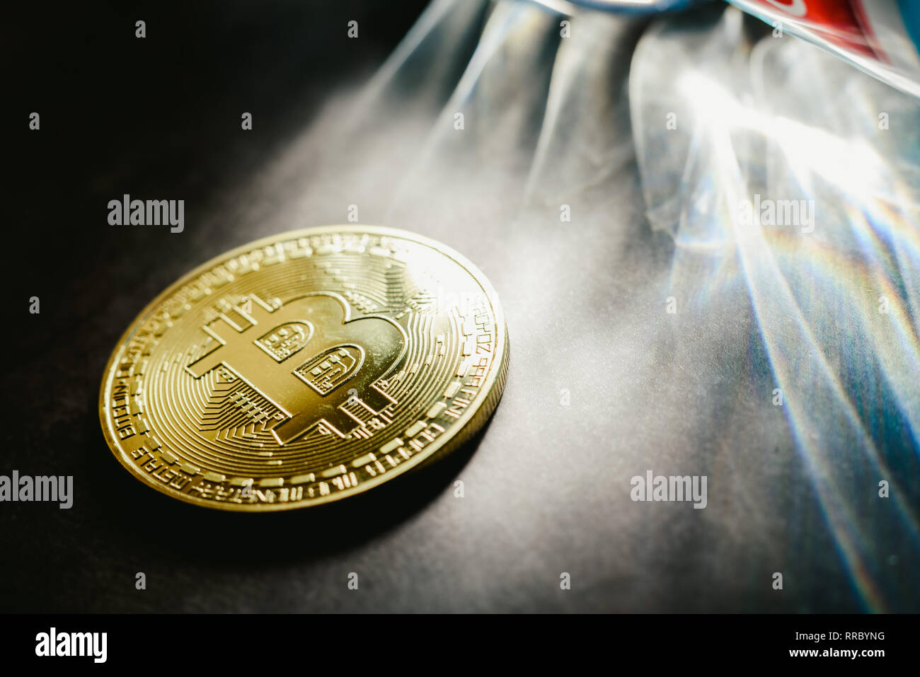 Bitcoin physical coins illuminated by light rays with dark background ...