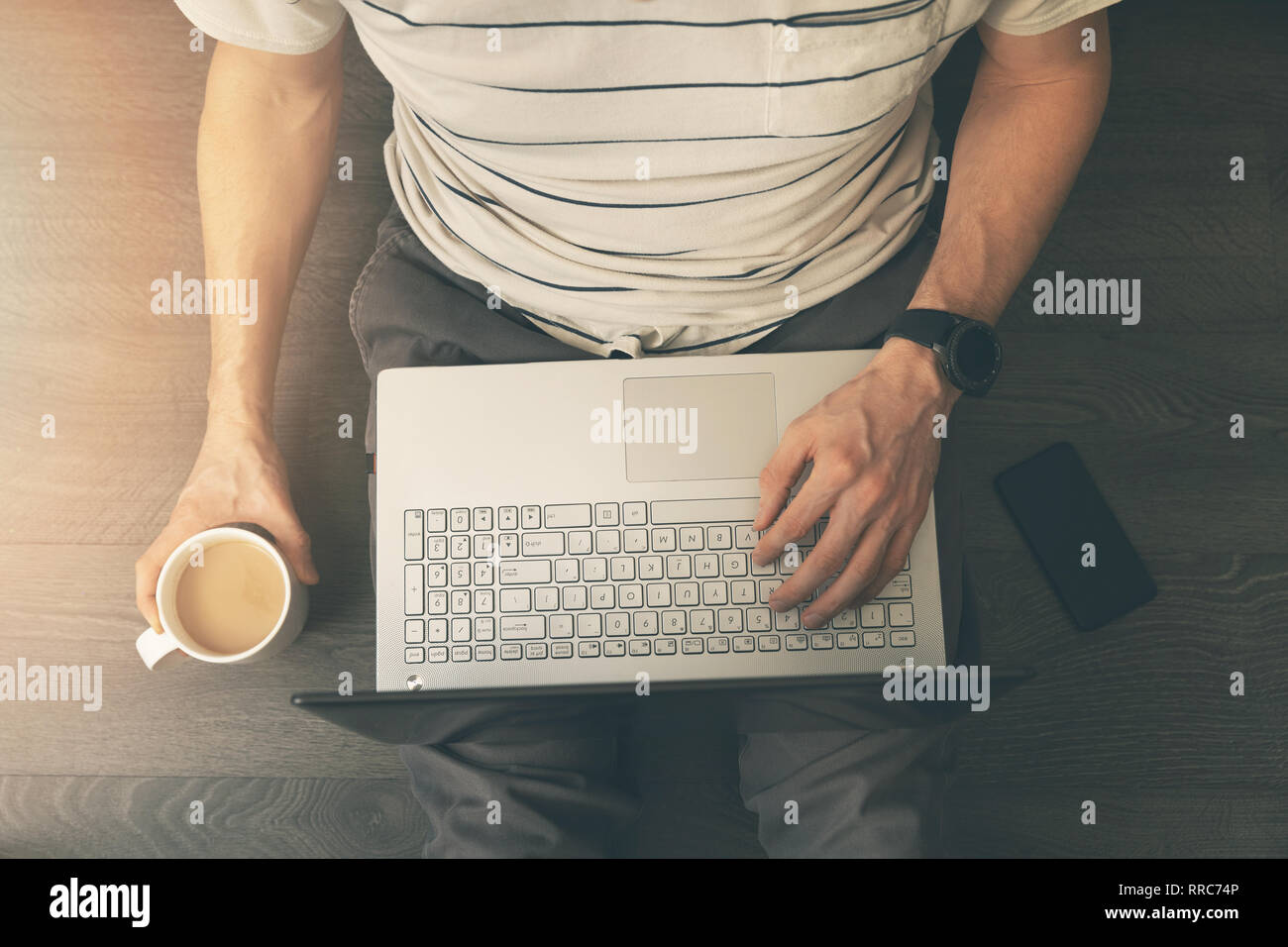 man sitting on the floor and using laptop computer at home. top view ...