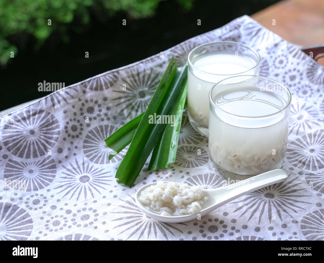 Barley water or soup in glasses and cooked pearly barley on spoon with ...