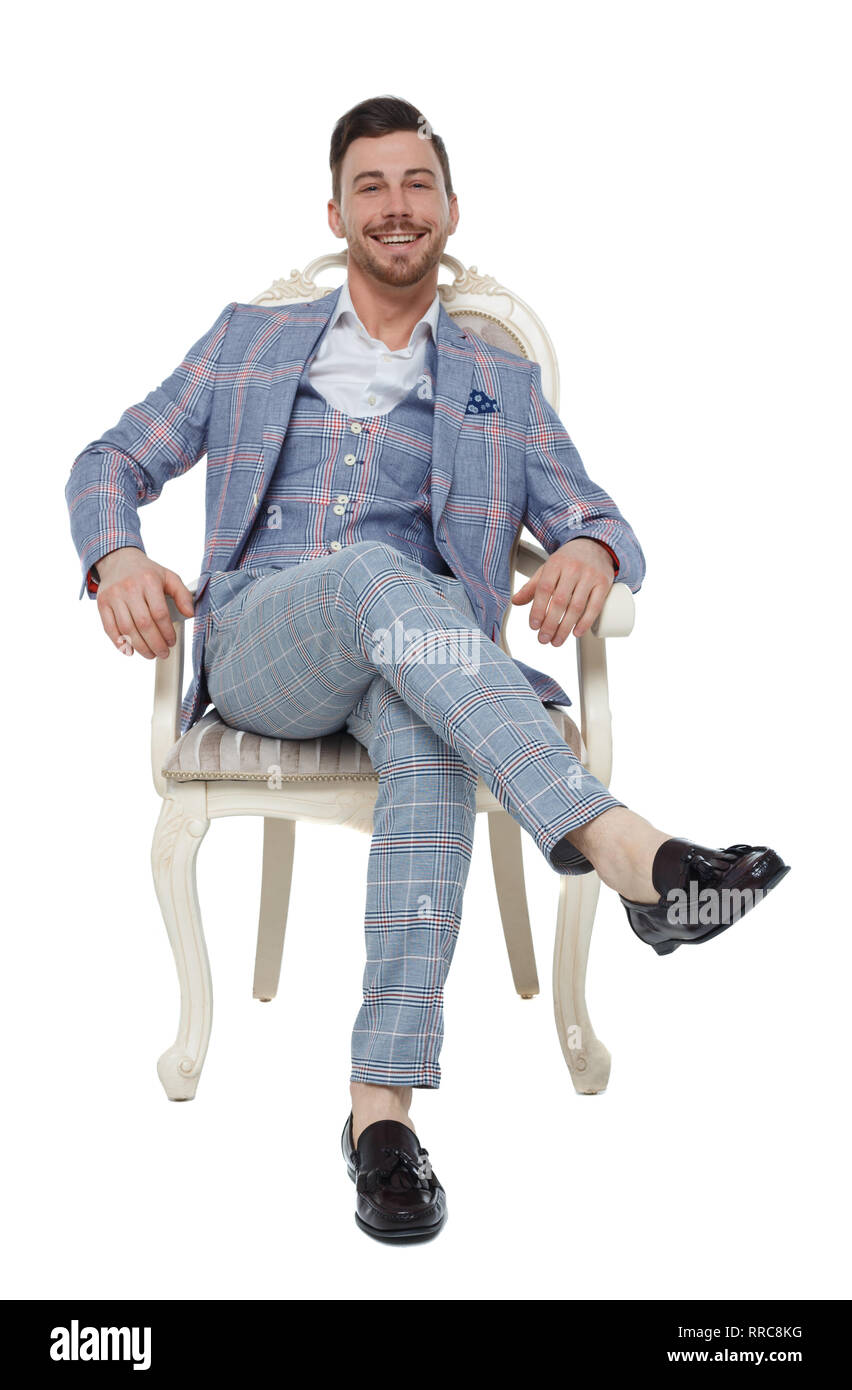 A man in a suit is sitting on an expensive chair. Front view of a guy ...