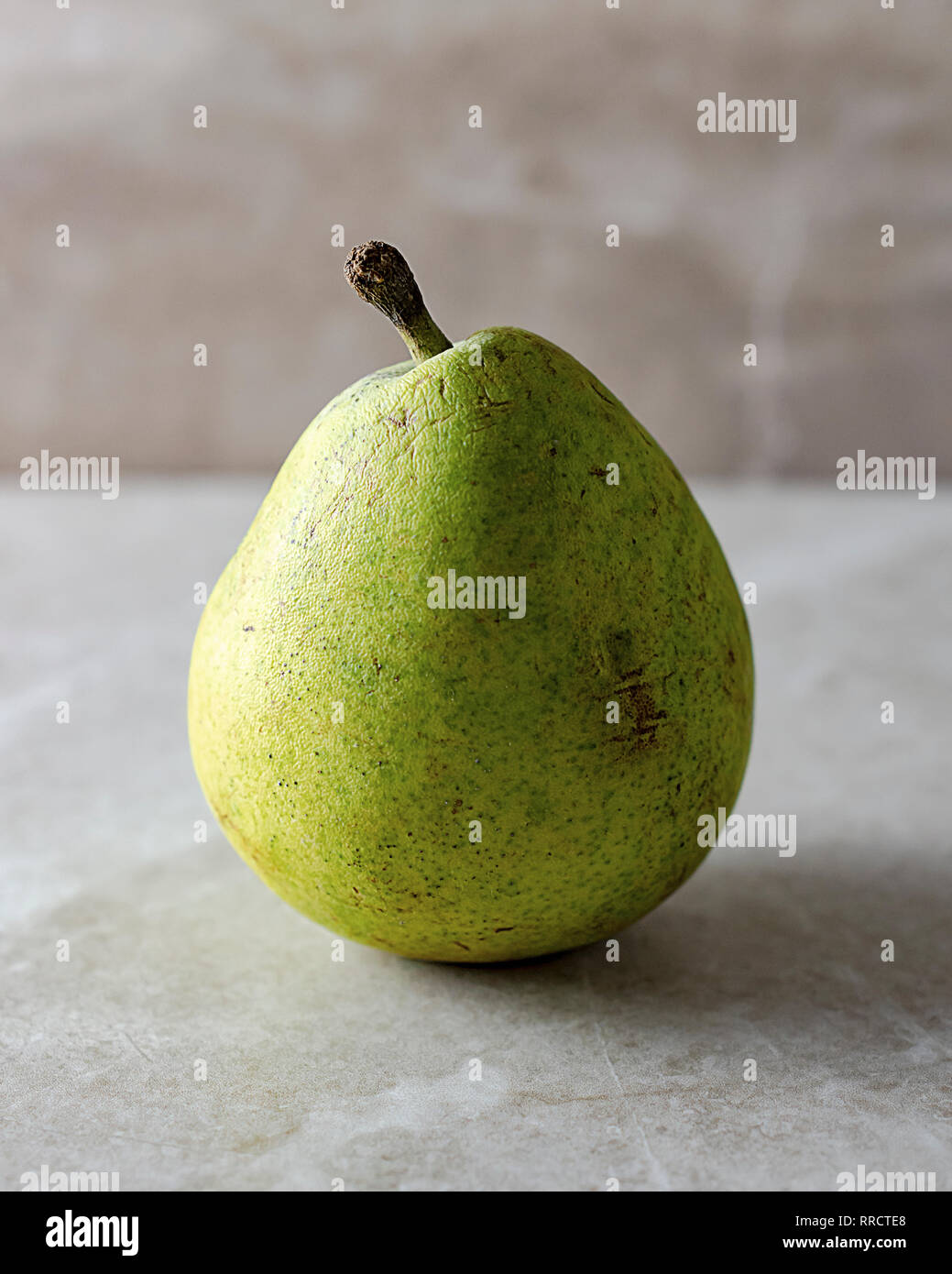 Close up view of a single pear on stone tile background. Dramatic ...