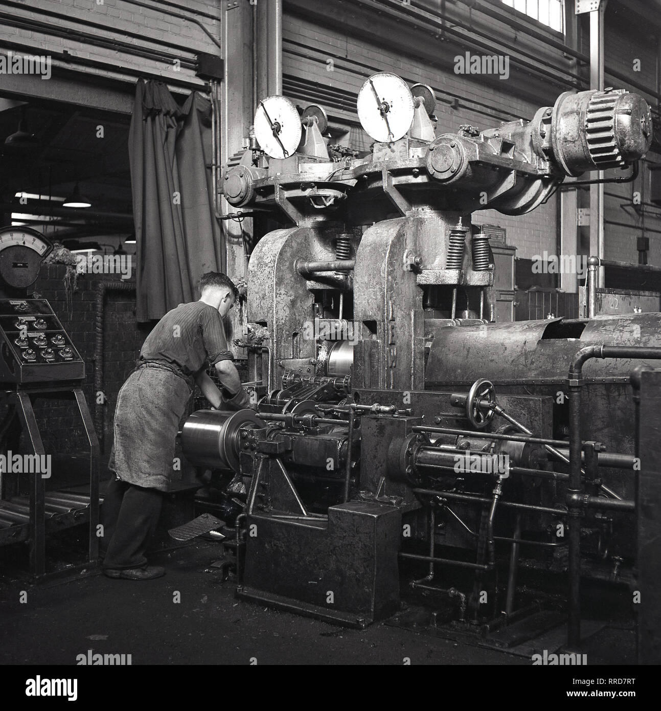 1950s, male worker working on a large piece of machinery in a battery ...